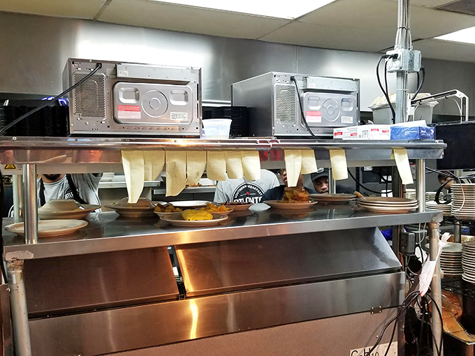 Where the magic happens. Order tickets flutter like culinary prayers while skilled hands transform simple ingredients into morning masterpieces.