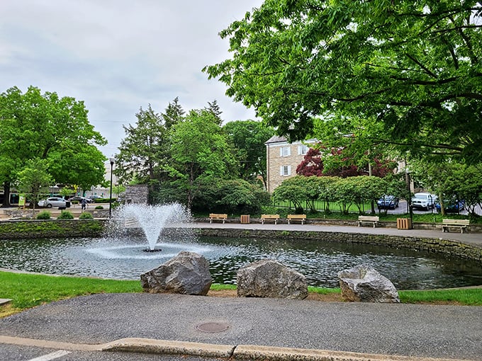 Lititz Springs Park's fountain creates a tranquil centerpiece for this beloved community gathering space, where benches invite contemplation under leafy guardians.