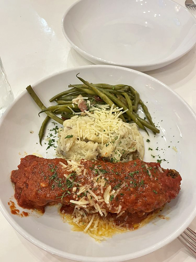 Comfort food gets dressed up for dinner&mdash;hearty meatloaf smothered in rich tomato sauce alongside creamy mashed potatoes and vibrant green beans.