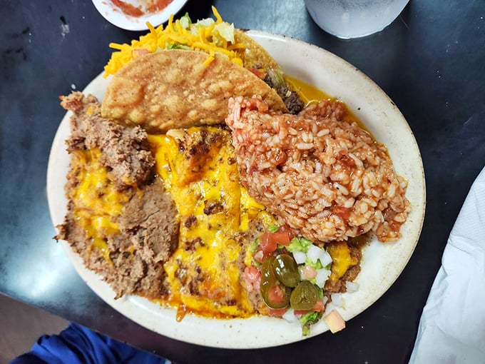 The Mexican plate delivers a symphony of textures and flavors, where cheese-blanketed enchiladas conduct an orchestra of rice, beans, and savory satisfaction.
