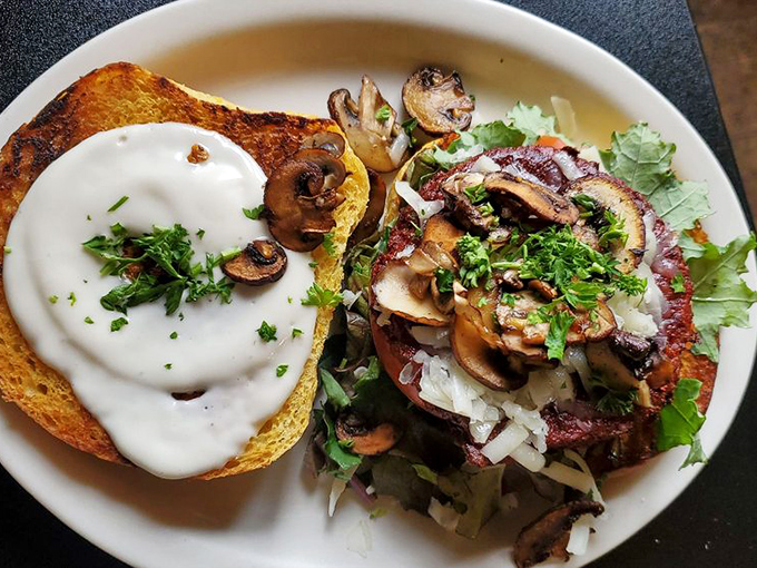 This mushroom creation isn't just a sandwich&mdash;it's architecture. The creamy sauce cascades over perfectly grilled toast like a delicious waterfall.