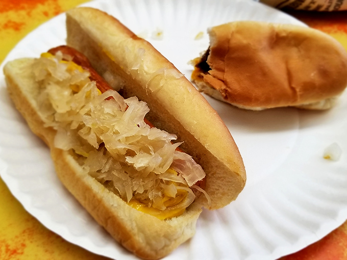 Sauerkraut piled high enough to make a German grandmother proud. This hot dog doesn't just have toppings—it's wearing a tangy crown.
