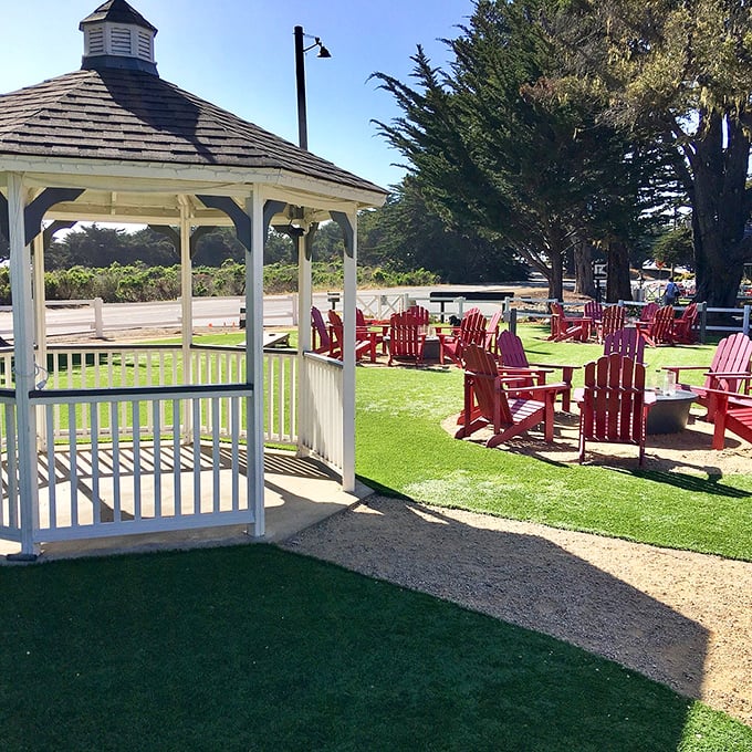 White gazebo, emerald lawn, crimson chairs&mdash;this seaside color palette is California coastal design at its most inviting.