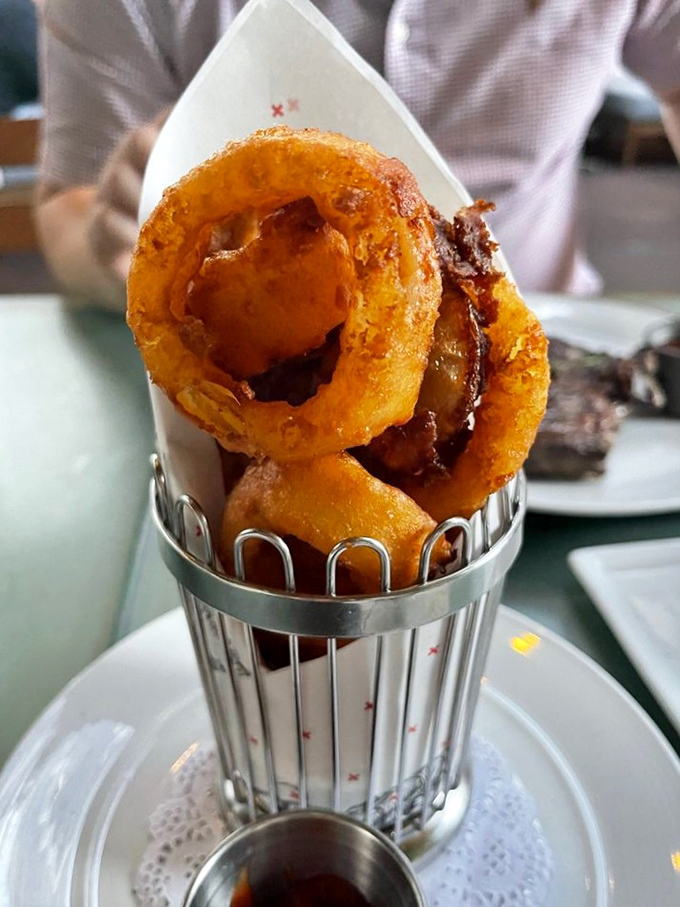 These aren't just onion rings—they're golden halos of crispy perfection, stacked like delicious jewelry and worthy of their own spotlight.