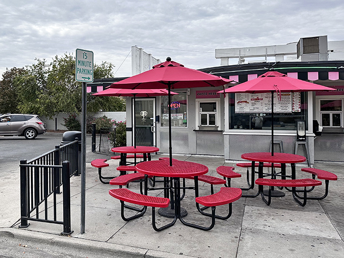 Red umbrellas dot the patio like cherry tops on sundaes, offering shade for those who prefer their nostalgia with a side of fresh air.