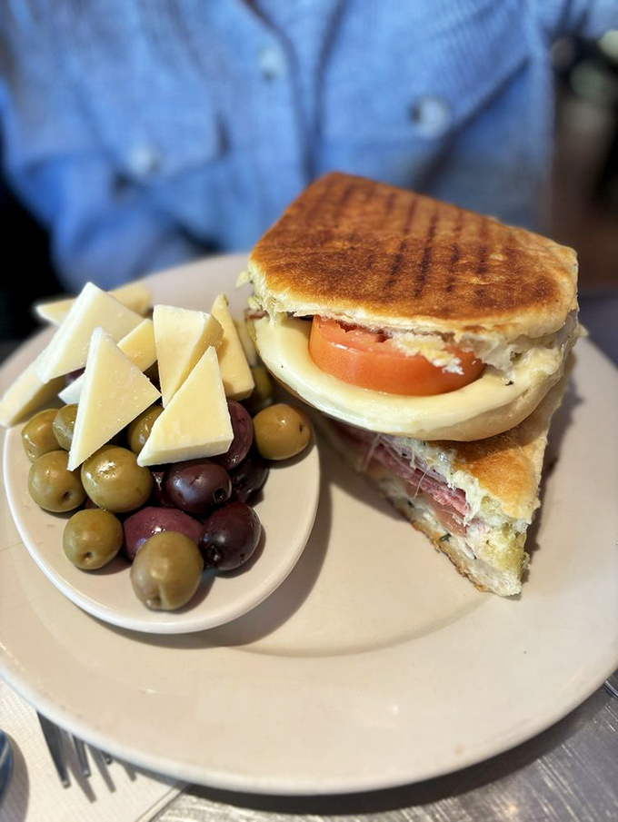 The panini arrives with a supporting cast of olives and cheese, a savory prelude to the sweet symphony that follows.