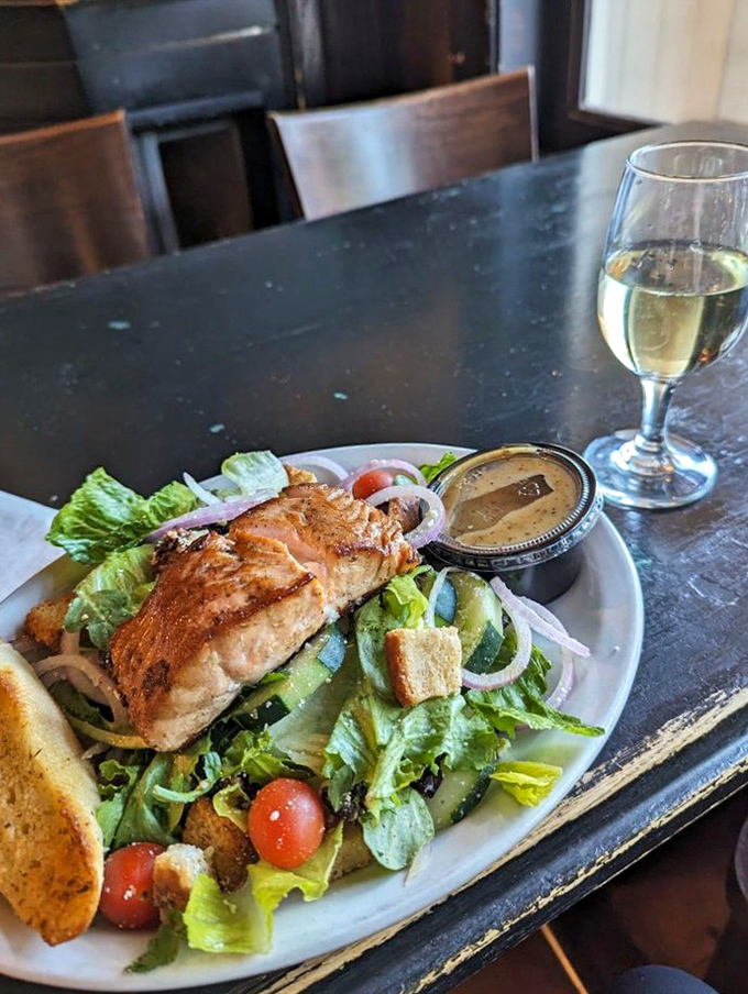 A salmon salad that makes eating greens feel like a privilege rather than a punishment. Fresh, colorful, and paired with a glass of white wine.