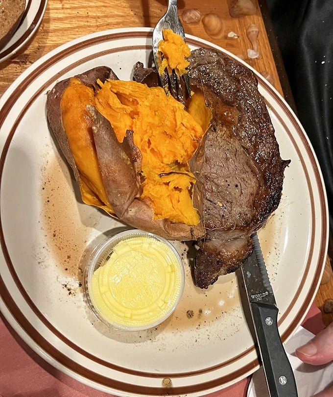 A ribeye that could make a vegetarian weep, paired with a sweet potato that's having its own moment of buttery glory.
