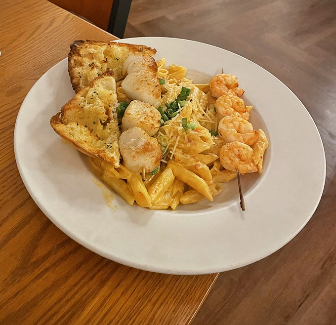 Pasta that doesn't just host seafood but celebrates it, with scallops and shrimp nestled among penne like treasures in a delicious chest.