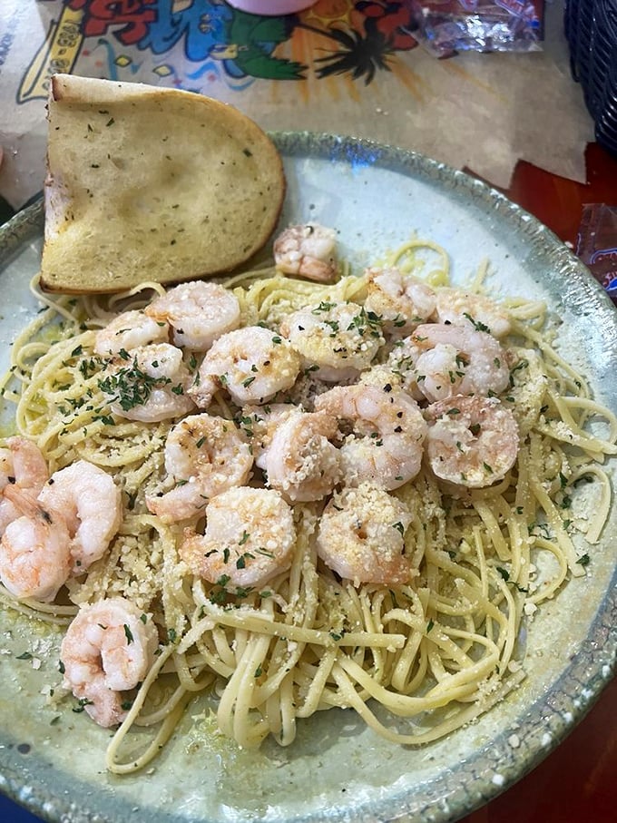 Plump shrimp dance across a sea of pasta, glistening with garlic butter that demands to be sopped up with that accompanying garlic bread.