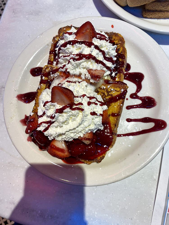 French toast that looks like it's auditioning for a dessert competition. Those strawberries and cream aren't just toppings &ndash; they're a flavor entourage.