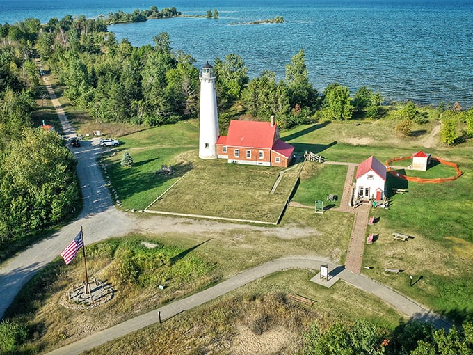 Tawas Point Lighthouse stands like a maritime sentinel against Lake Huron's blue canvas. This postcard-perfect scene has been guiding sailors and photographers for generations.