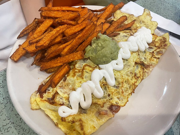 This isn't just an omelet – it's an architectural achievement of eggs, topped with a zigzag of sauce that says "I'm not your average breakfast."