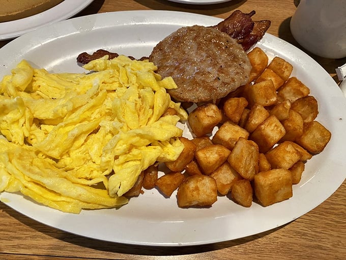 The breakfast trinity: perfectly sunny eggs, golden hash browns, and savory meat &ndash; a plate that solves all morning dilemmas at once.