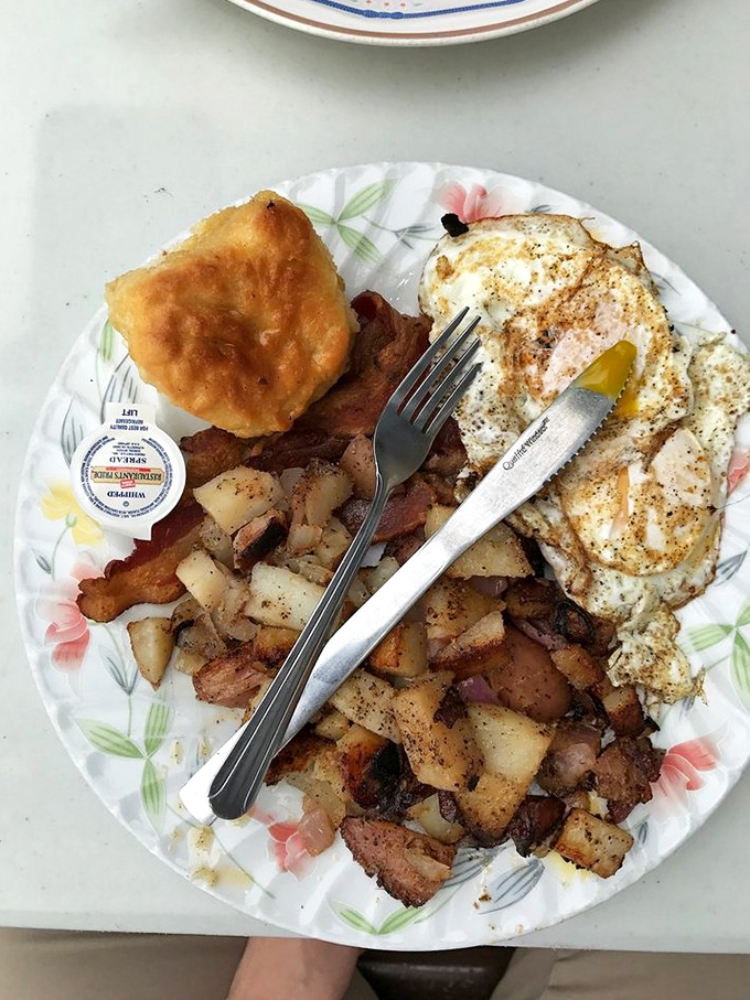 The breakfast trinity: perfectly fried eggs, crispy-edged hash browns, and a biscuit that makes you question every other biscuit you've ever known.