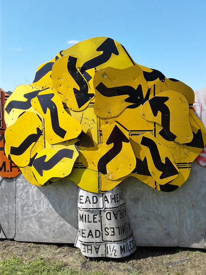 A tree of knowledge grown from directional arrows. This sunny sculpture branches out with curves that once guided drivers but now lead the eye on a different journey.