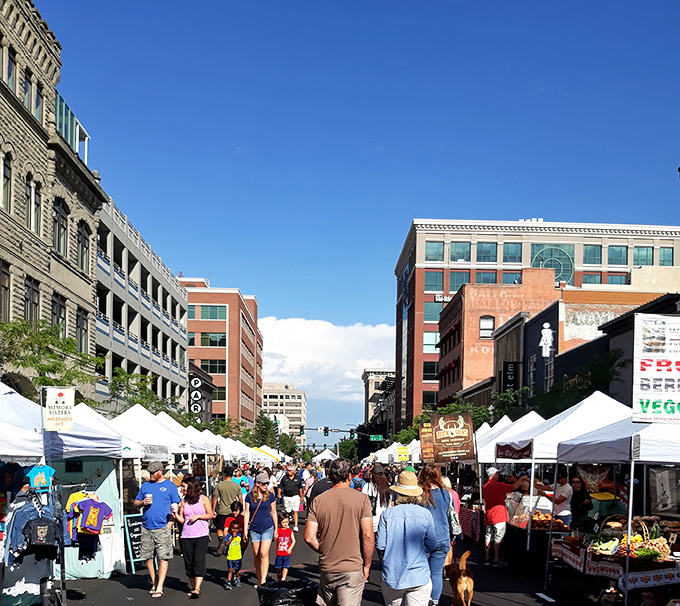 The market stretches down the urban canyon of downtown Boise, a weekly ritual that turns ordinary streets into extraordinary gathering spaces.