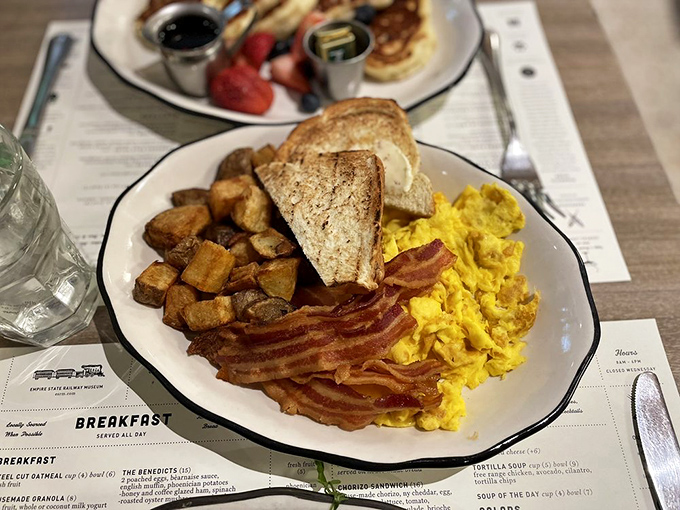 The breakfast trinity: golden eggs, crispy potatoes, and bacon that had a purpose in life. This plate doesn't need filters&mdash;it needs a moment of silence.