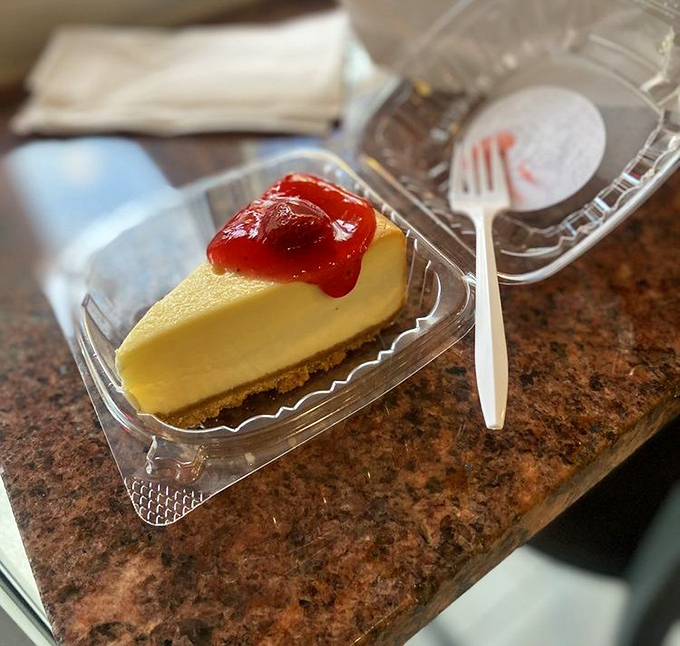 A slice of cheesecake with strawberry topping&mdash;because after conquering a mountain of chicken, you've earned this sweet victory lap.