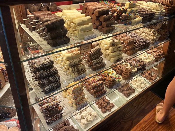 A glass case of temptation where chocolate dreams come true. Each shelf offers a different excuse to abandon your diet resolutions.