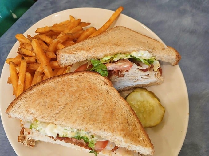 The club sandwich: where turkey, bacon, and veggies hold a delicious summit meeting. Served with fries that deserve their own fan club.