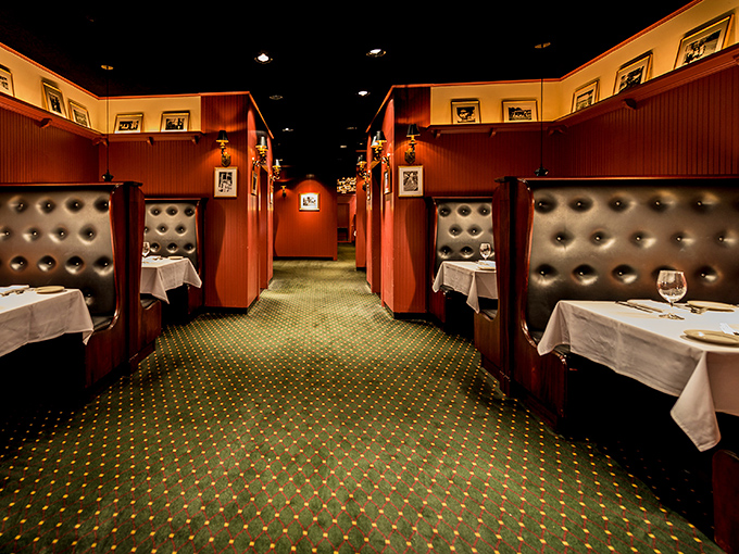 The dining room layout&mdash;like a series of cozy red velvet cocoons. Each booth offers that perfect balance of privacy and "yes, we're somewhere special" atmosphere.