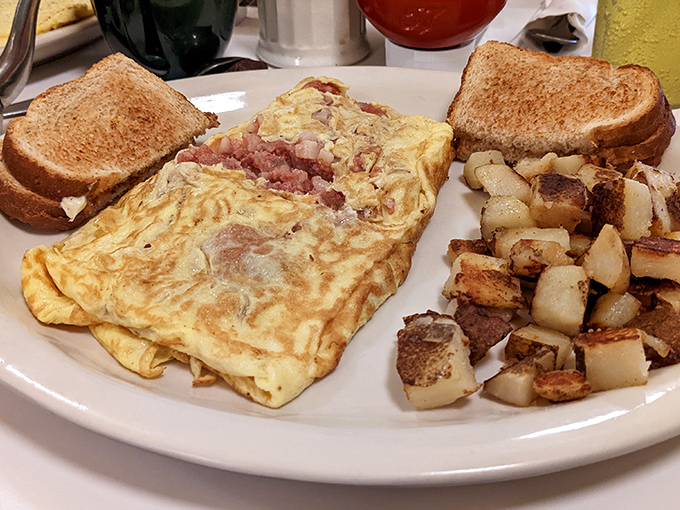 This ham-packed omelet could feed a steel worker through double shifts, with home fries standing guard like delicious, golden sentinels.