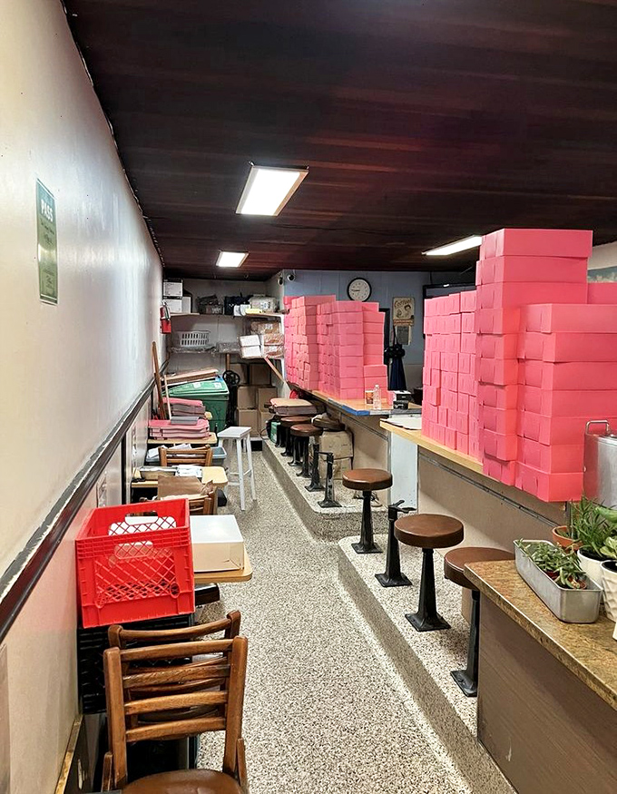 Pink donut boxes stacked like sweet skyscrapers hint at the serious business of happiness happening here.