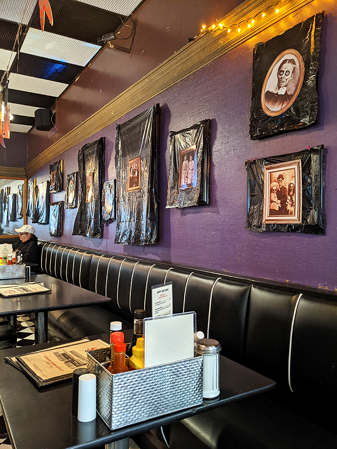 The purple walls adorned with vintage portraits create an atmosphere that's part haunted mansion, part cozy diner&mdash;somehow it works perfectly.
