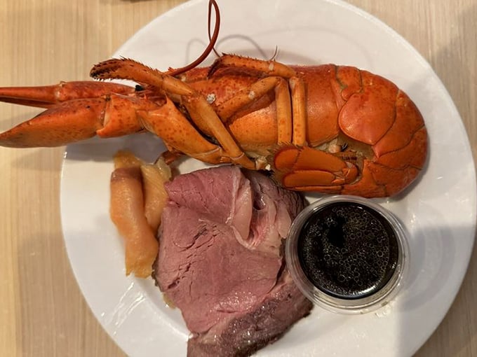 The ultimate power couple: a whole Maine lobster and prime rib, accompanied by a mysterious black condiment that promises flavor adventure.
