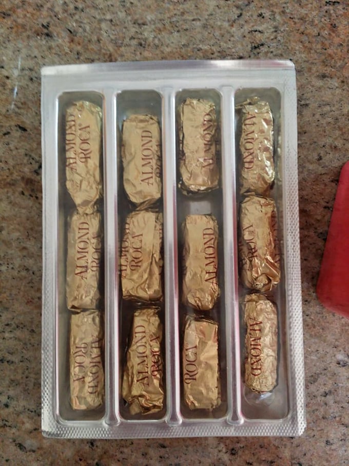 Perfectly aligned Almond Roca pieces await their destiny in a plastic tray. Resistance is futile, surrender is delicious.
