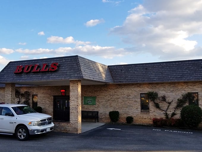 Sunlight catches Bulls Steakhouse's iconic sign. Where the parking lot is full, the prices are fair, and the steaks are legendary.