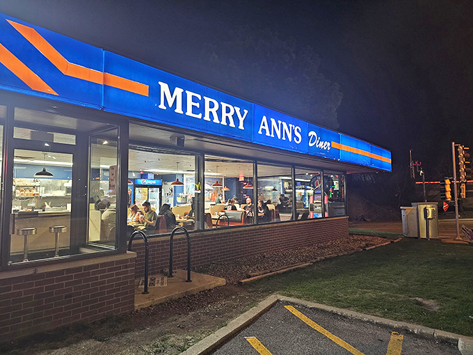 The blue and orange beacon of Merry Ann's Diner glows like a midnight oasis, promising salvation in the form of perfectly crispy hash browns and endless coffee.