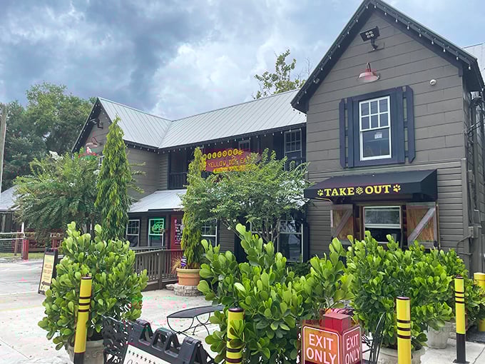 The charming gray cottage with its metal roof and lush greenery feels like stumbling upon a secret clubhouse for sandwich enthusiasts.