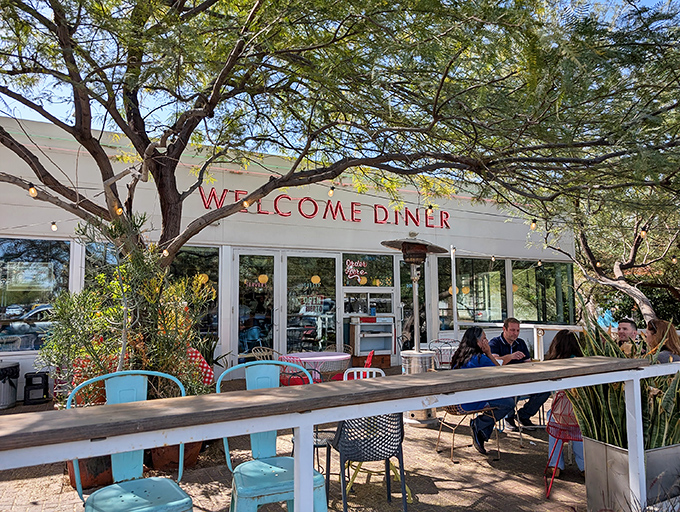 The iconic red lettering beckons hungry travelers like a desert mirage, promising comfort food salvation under the shade of Arizona mesquite trees.