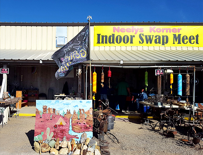 The bright yellow sign of Neely's Korner beckons like a desert mirage, promising treasures within. Desert artwork and wind chimes hint at the eclectic offerings awaiting inside.
