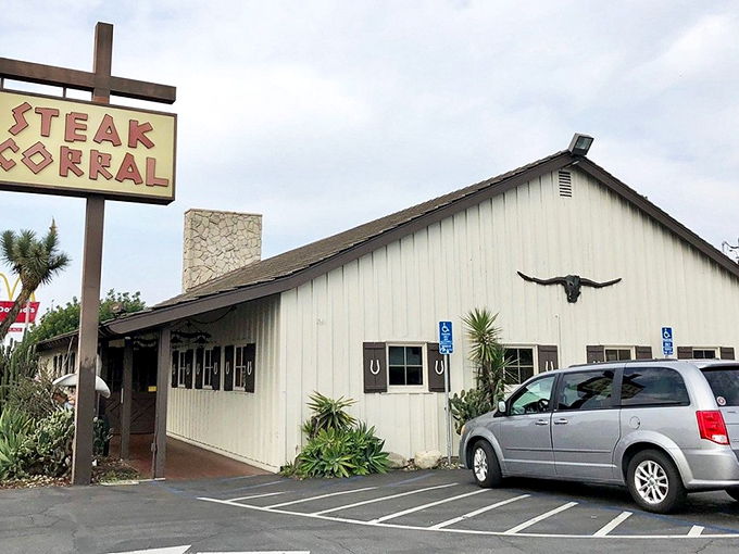 The unassuming exterior of Steak Corral stands like a time capsule of classic California dining, complete with longhorn skull and vintage signage.