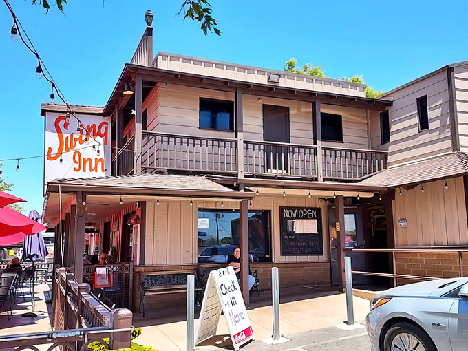 The Swing Inn's rustic wooden facade and vintage orange sign stand as a time capsule in Temecula's Old Town, beckoning hungry travelers with promises of smoky delights.