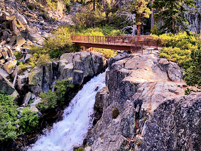Nature's perfect postcard: Eagle Falls cascades dramatically over granite cliffs while a rustic footbridge offers the ideal vantage point for that "I can't believe this is real" moment.