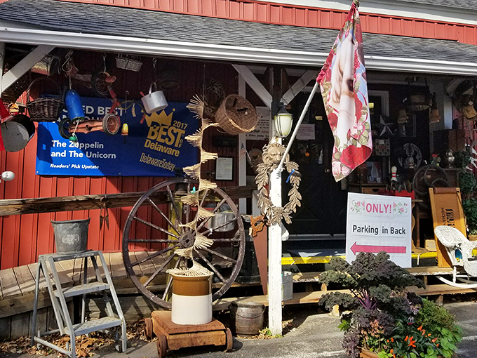 The charming red barn exterior welcomes treasure hunters with its colorful garden display and vintage wagon wheel. A nostalgic portal to the past awaits!