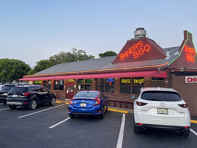 That neon glow isn't just for show&mdash;it's a barbecue beacon calling hungry souls to this log cabin sanctuary where smoke signals promise delicious things ahead.