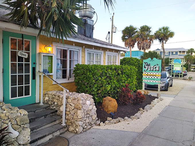 The cheerful yellow cottage with its mint-green door stands like a tropical beacon under Florida's impossibly blue sky.