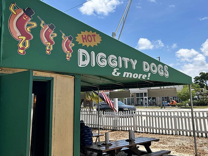 The emerald green awning of Hot Diggity Dogs beckons like a culinary lighthouse, promising simple pleasures and picnic table perfection.