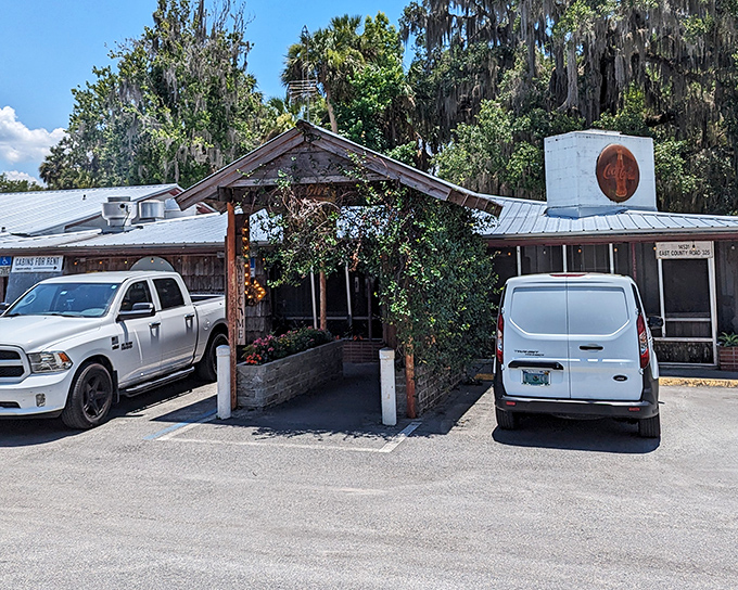 The unassuming exterior of The Yearling Restaurant stands as Florida's literary landmark turned culinary destination, Spanish moss and pickup trucks included.