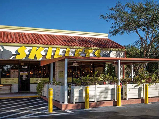 The sunshine-yellow Skillets sign promises breakfast paradise, standing out against Florida's blue sky like a beacon for hungry morning wanderers.