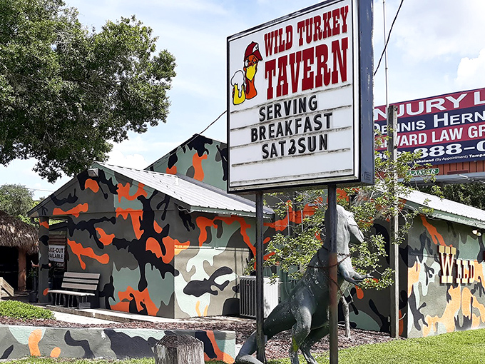 The unmistakable Wild Turkey Tavern exterior, where camouflage paint and a life-sized turkey statue announce you've found Florida's burger paradise.