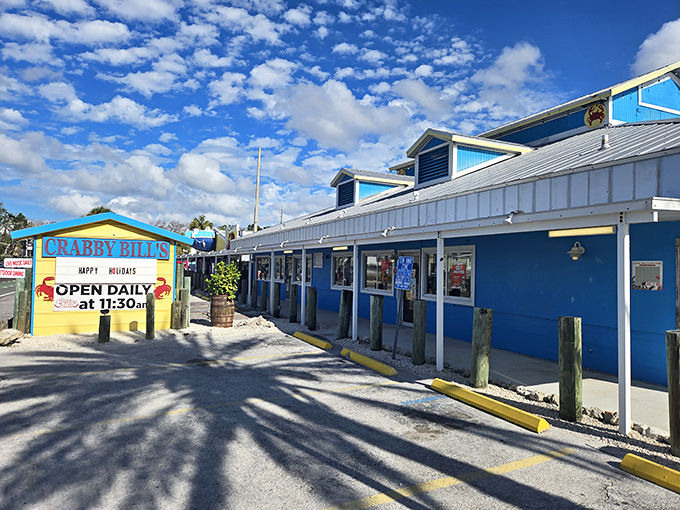 The colorful exterior of Crabby Bill's screams "Florida seafood joint" with its vibrant picnic tables and that iconic crab sign beckoning hungry beachgoers.