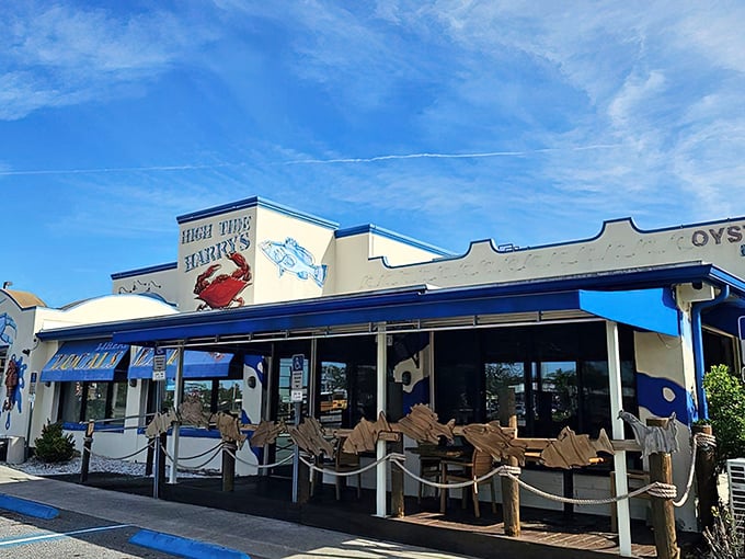 The blue and white facade of High Tide Harry's stands like a beacon for seafood lovers, promising treasures from the deep with its playful crab signage.