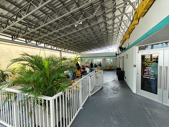 The covered patio entrance welcomes you with tropical plants and white railings&mdash;Florida's version of a burger paradise waiting to be discovered. 
