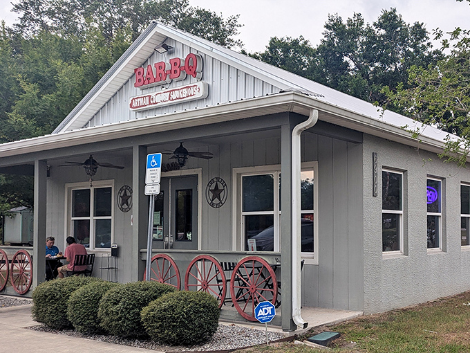 The white clapboard exterior of Artman Country Smokehouse beckons like a barbecue beacon, complete with rustic wagon wheels that say "slow down, good food ahead."
